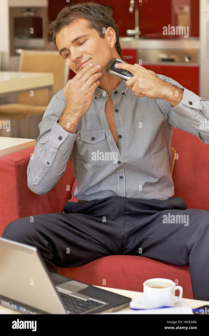 Young man shaving with electric shaver Stock Photo - Alamy