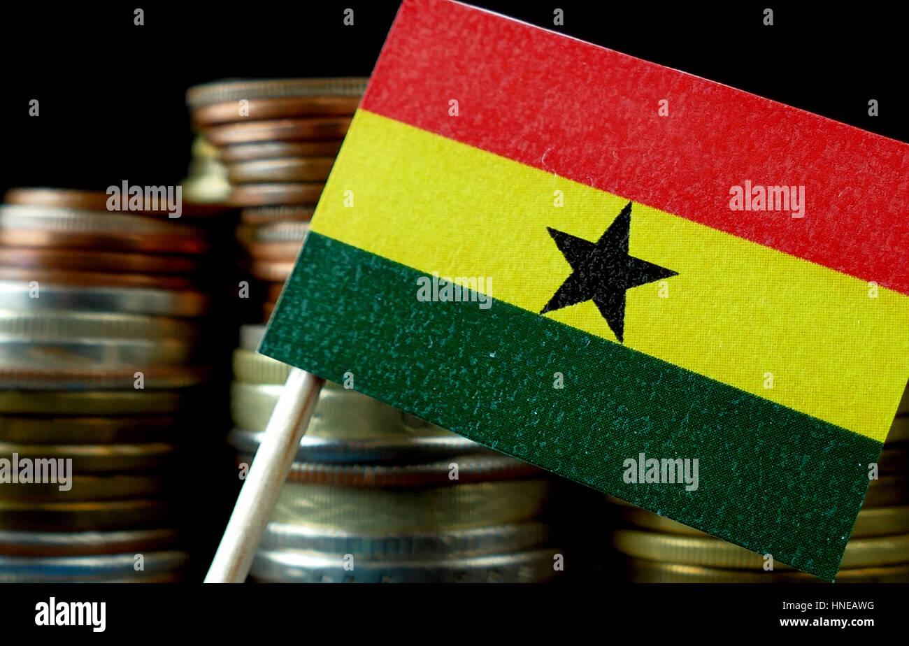 Ghana flag waving with stack of money coins macro Stock Photo - Alamy