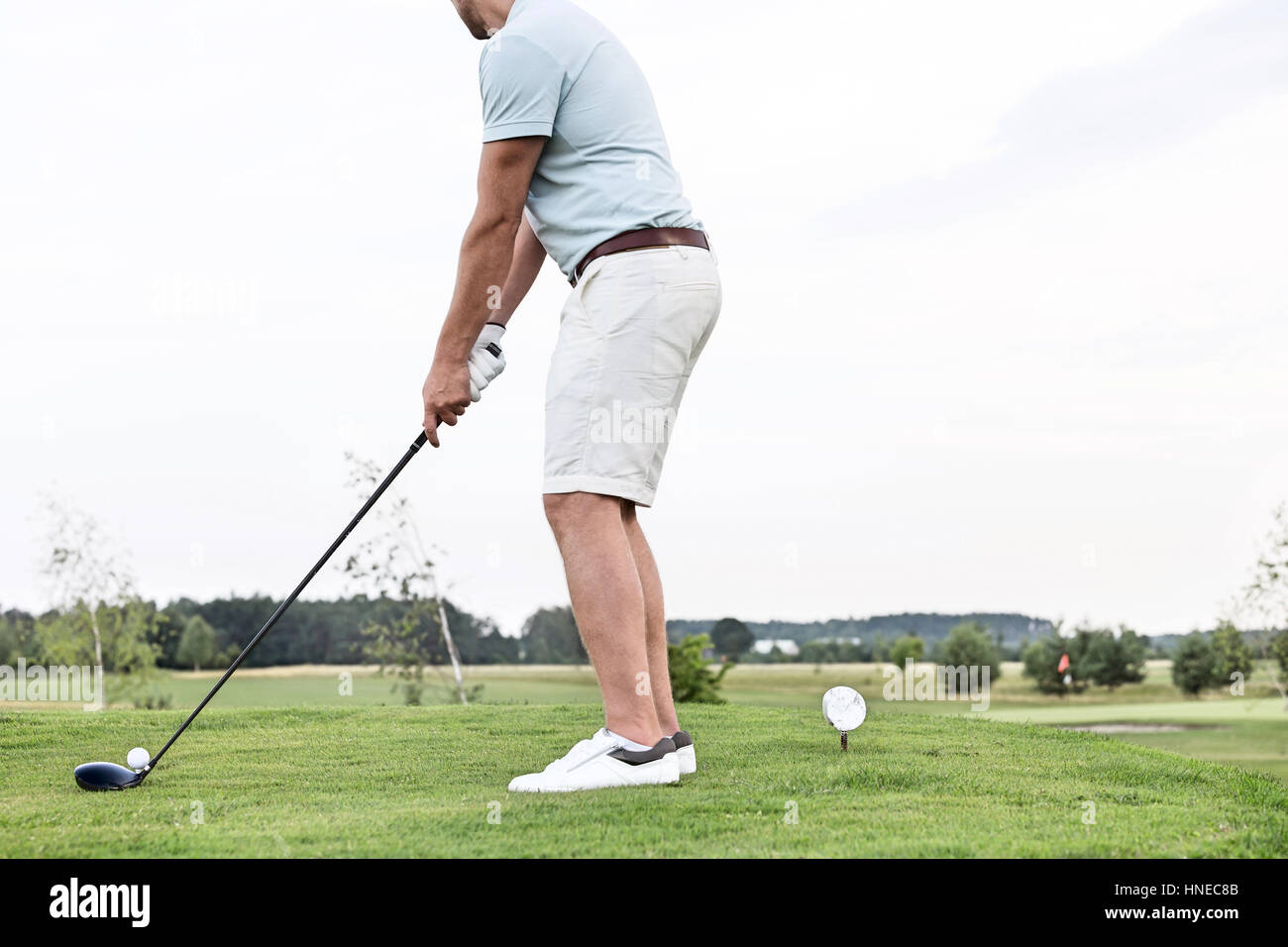 Low section side view of man playing golf against clear sky Stock Photo ...