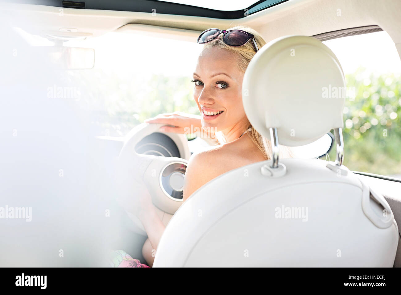 Rear view portrait of happy woman driving car Stock Photo - Alamy
