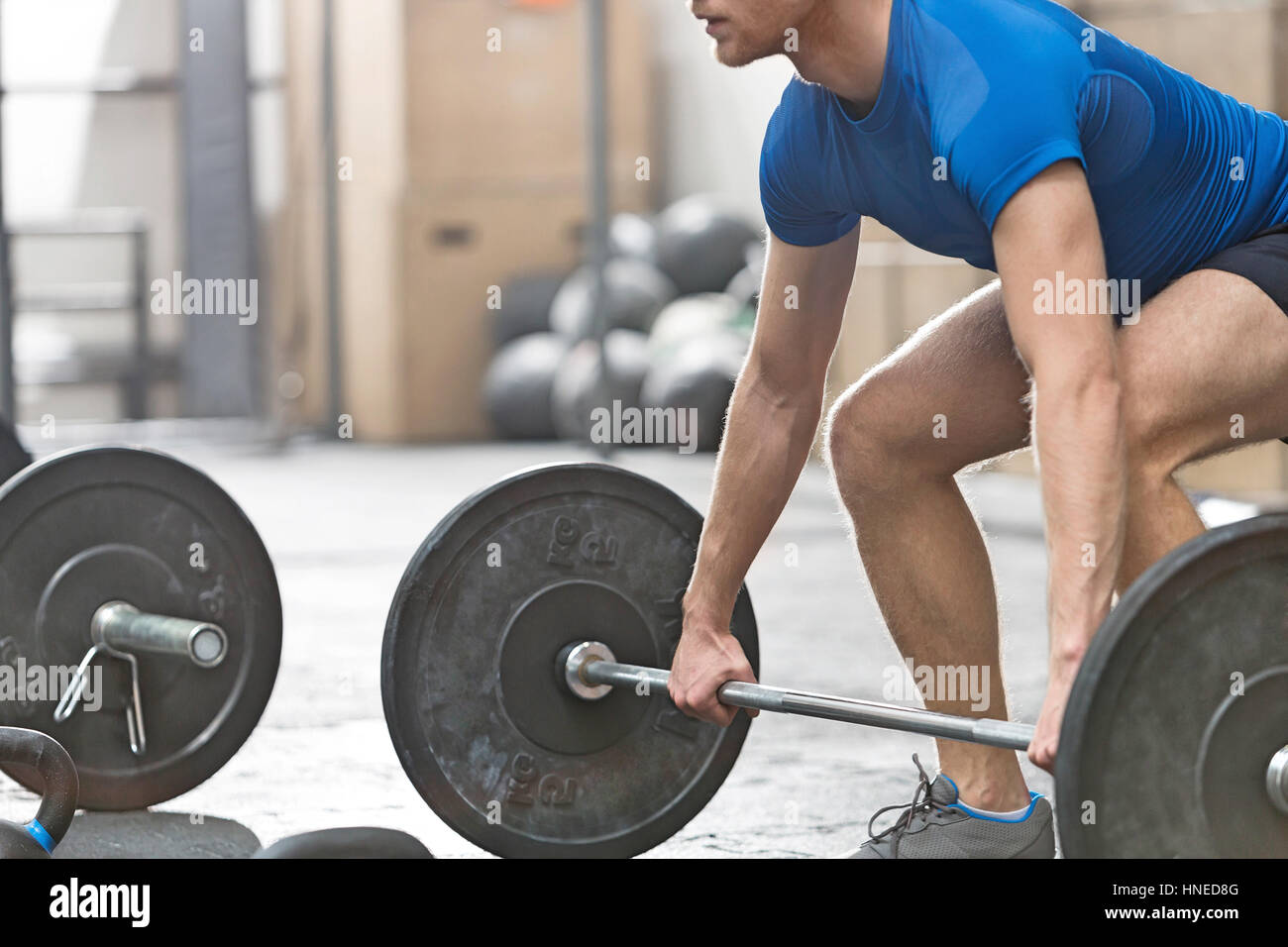 Low section of dedicated man lifting barbell in crossfit gym Stock ...