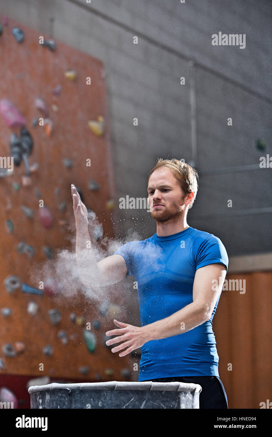 Man dusting powder by climbing wall in crossfit gym Stock Photo - Alamy