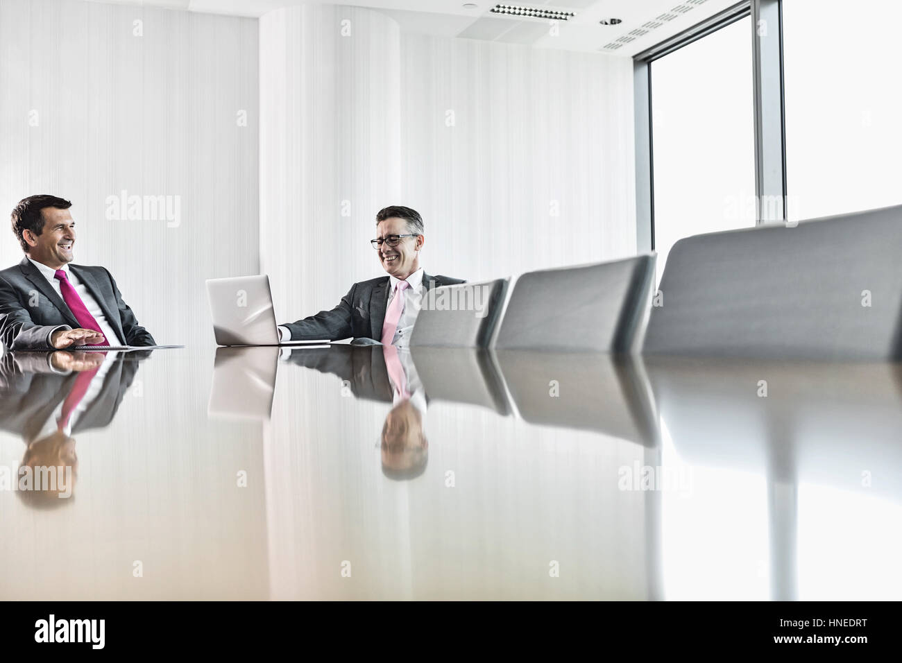 Smiling businessmen talking in conference room Stock Photo - Alamy