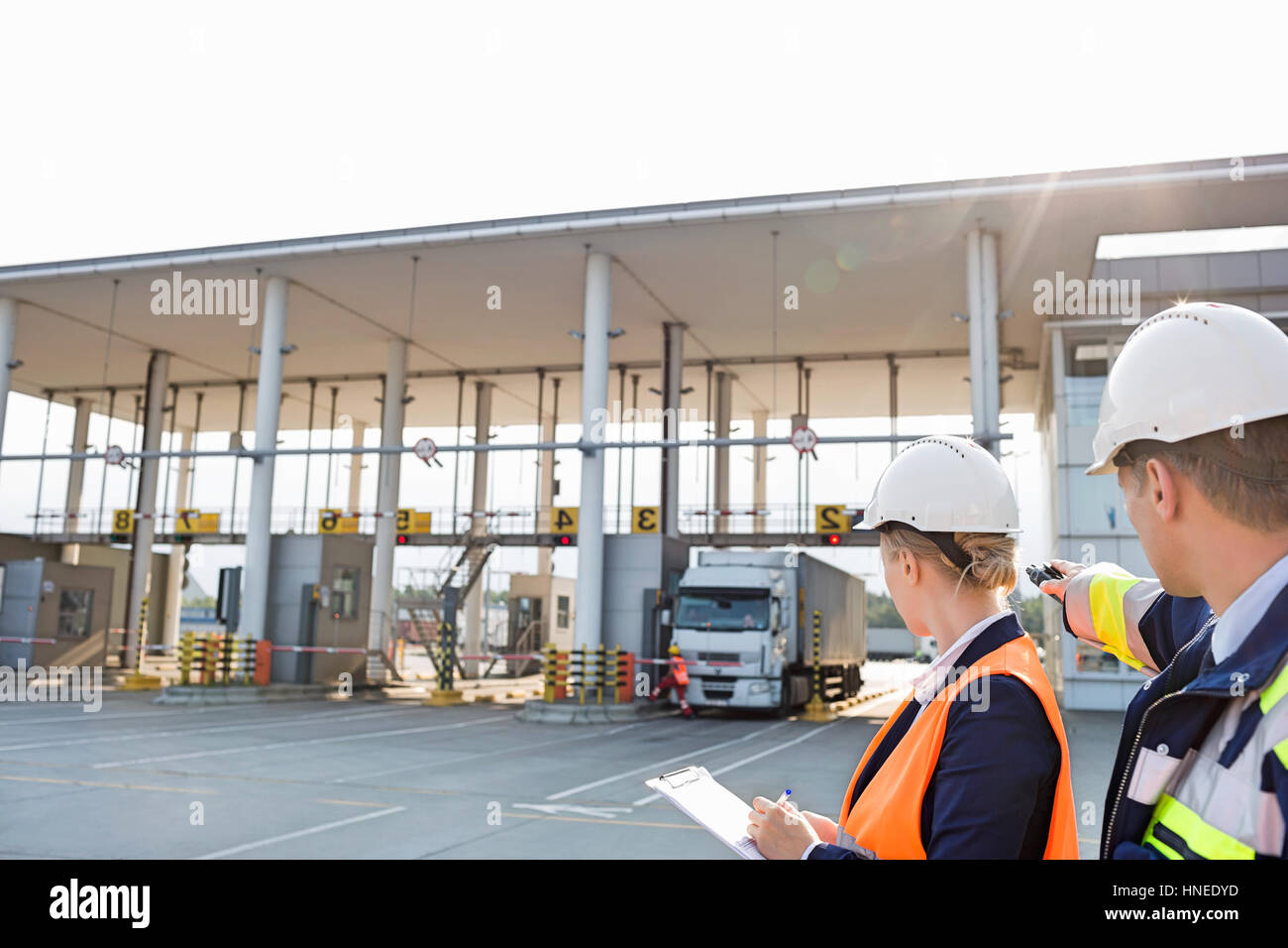 Supervisors looking at truck entering in shipping yard Stock Photo - Alamy
