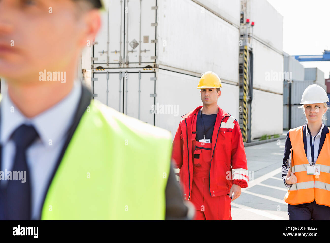 Workers walking in shipping yard Stock Photo - Alamy