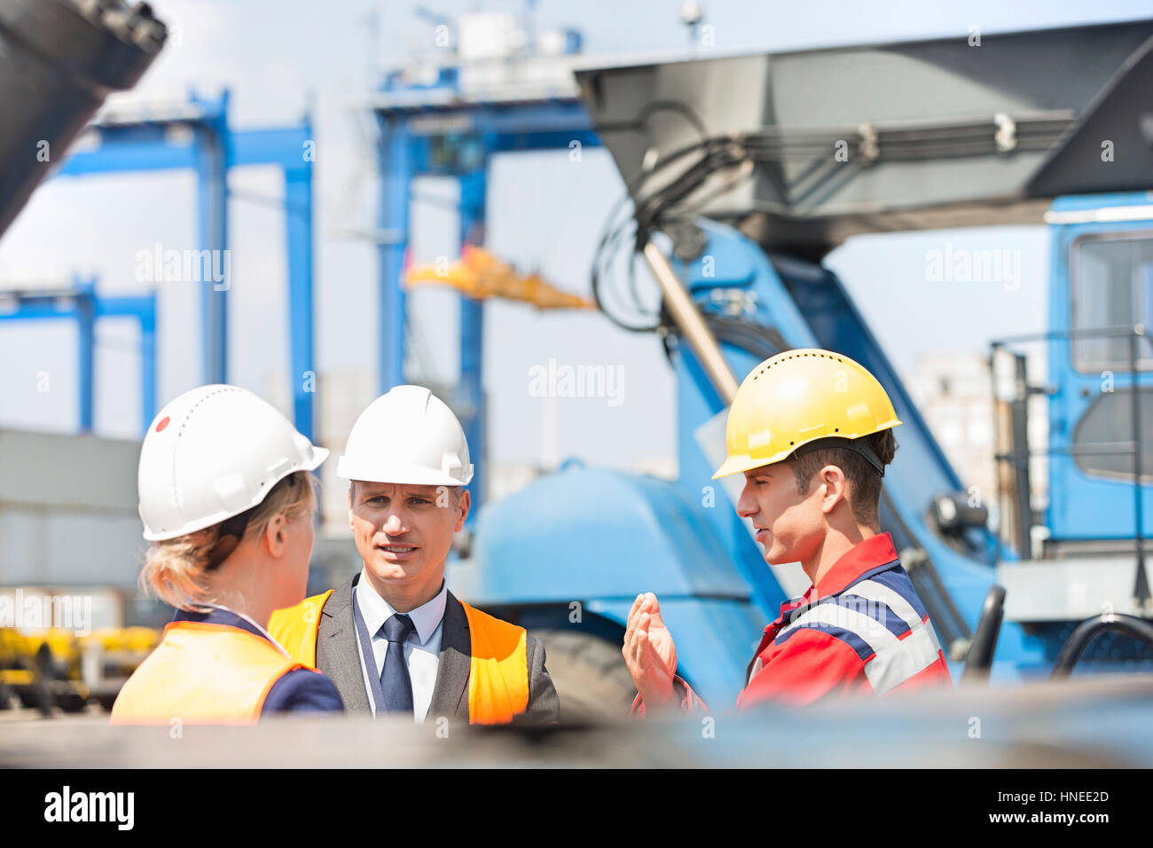 Workers discussing in shipping yard Stock Photo - Alamy