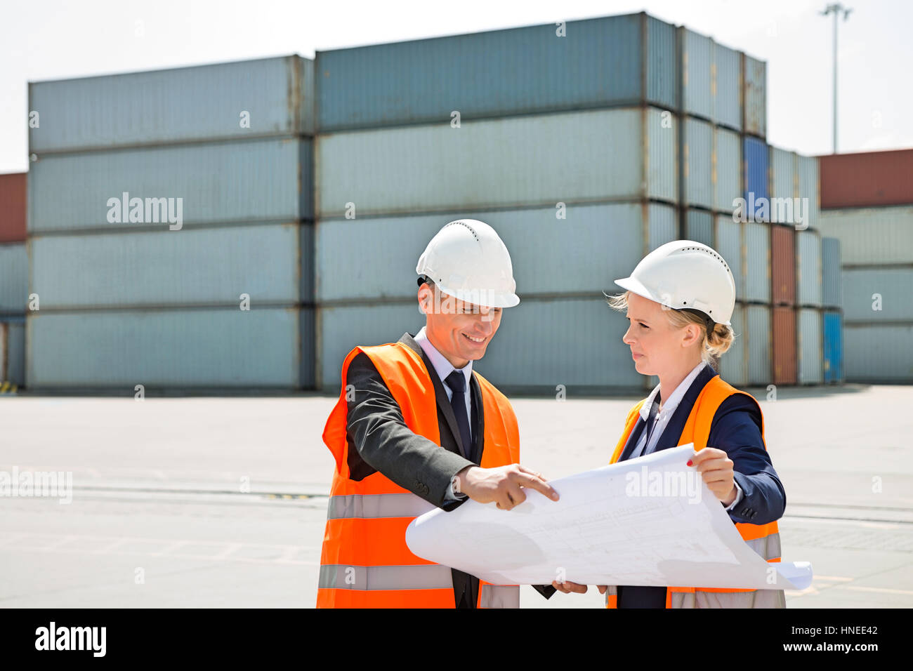 Engineers looking at blueprint in shipping yard Stock Photo - Alamy