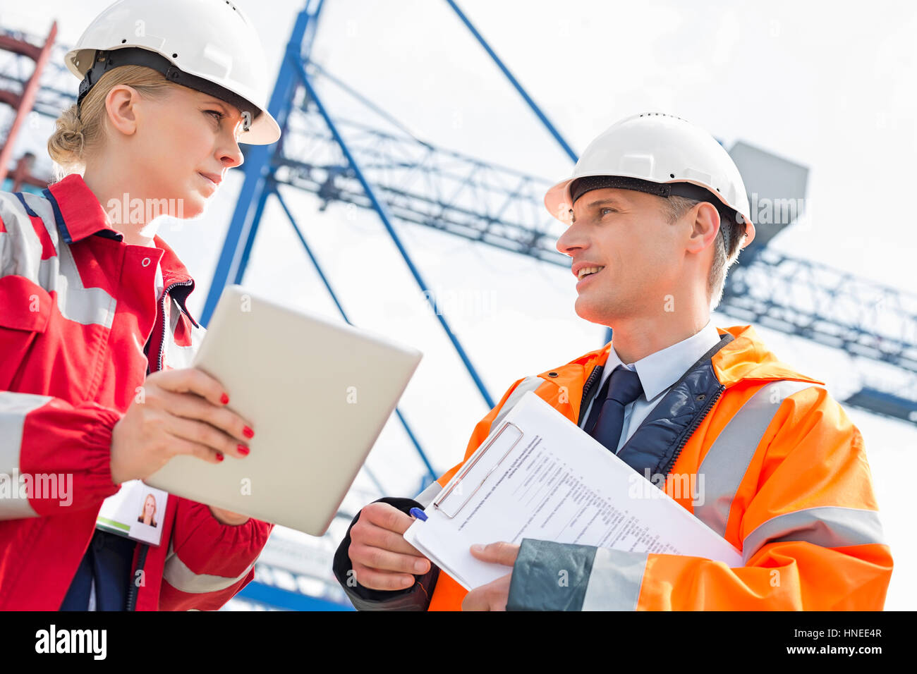 Workers discussing over tablet computer in shipping yard Stock Photo ...