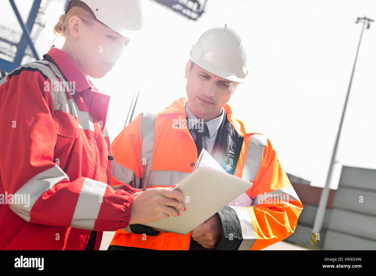 Workers discussing over tablet computer in shipping yard Stock Photo ...