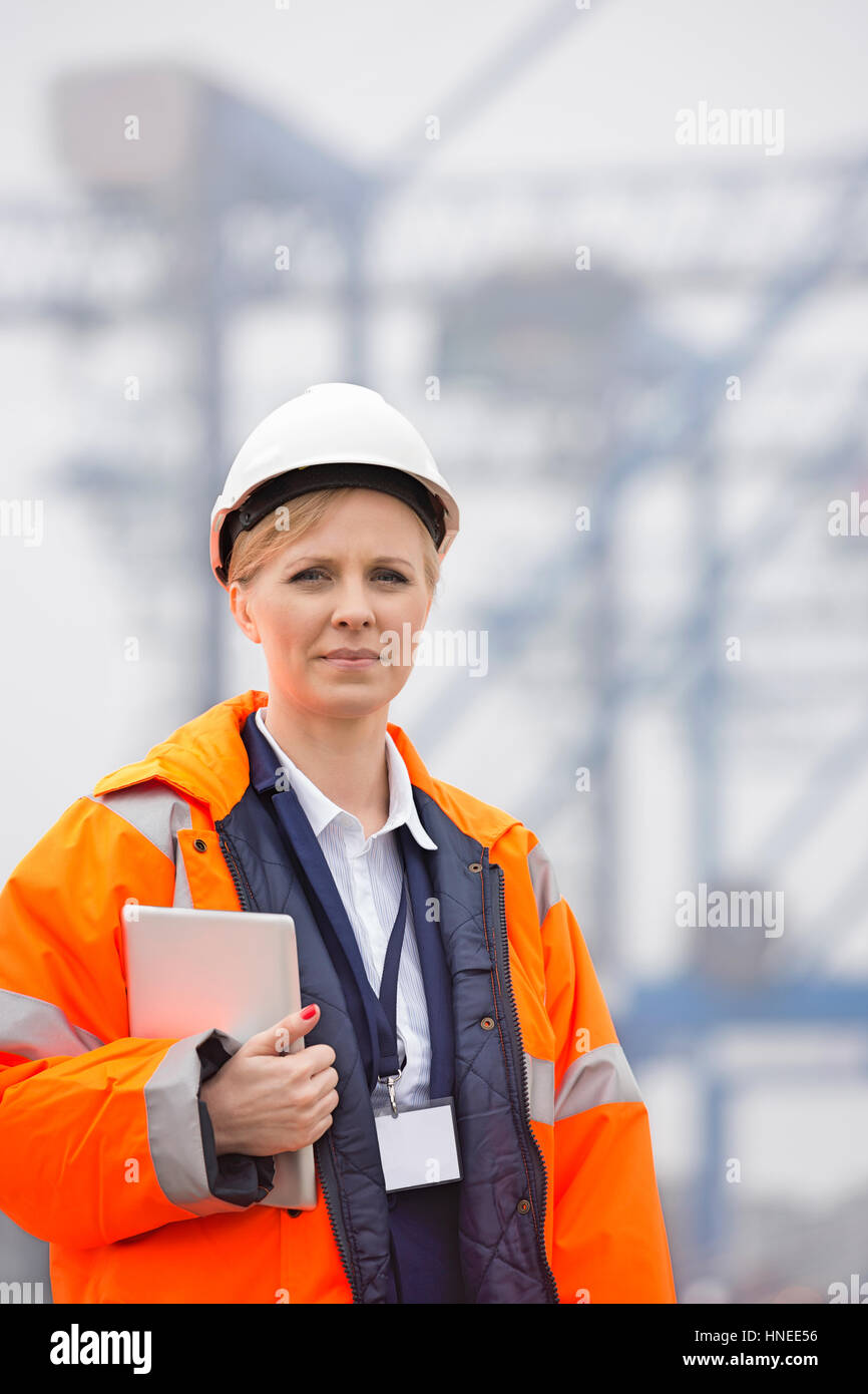 Female engineer holding tablet PC in shipping yard Stock Photo - Alamy