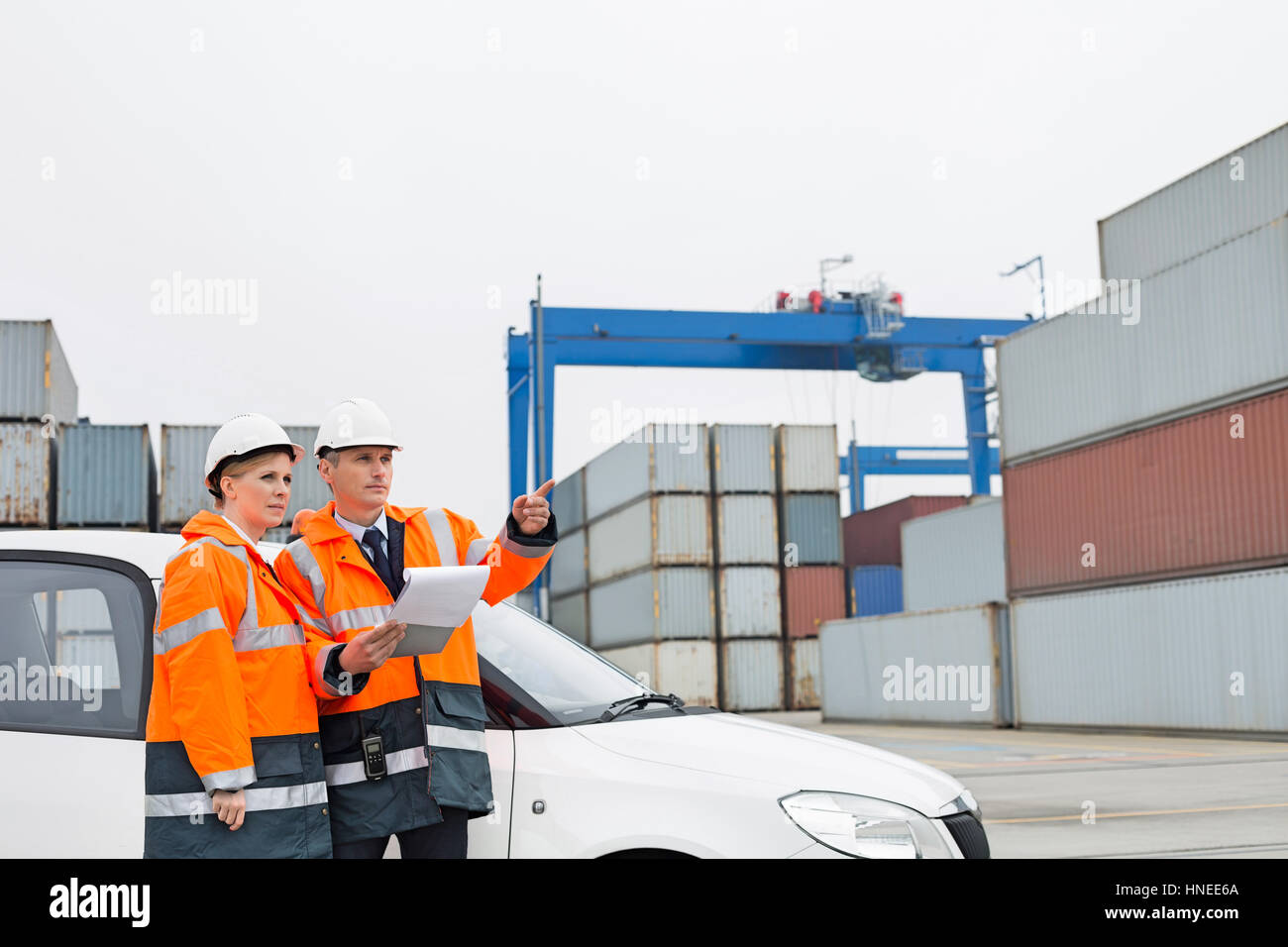 Workers examining cargo in shipping yard Stock Photo - Alamy