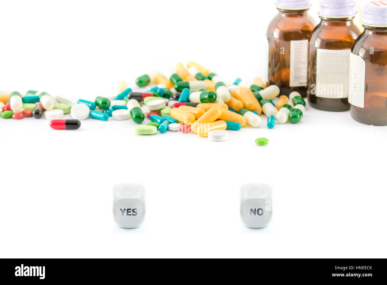 various capsules, tablets and container with yes or no dices in front ...