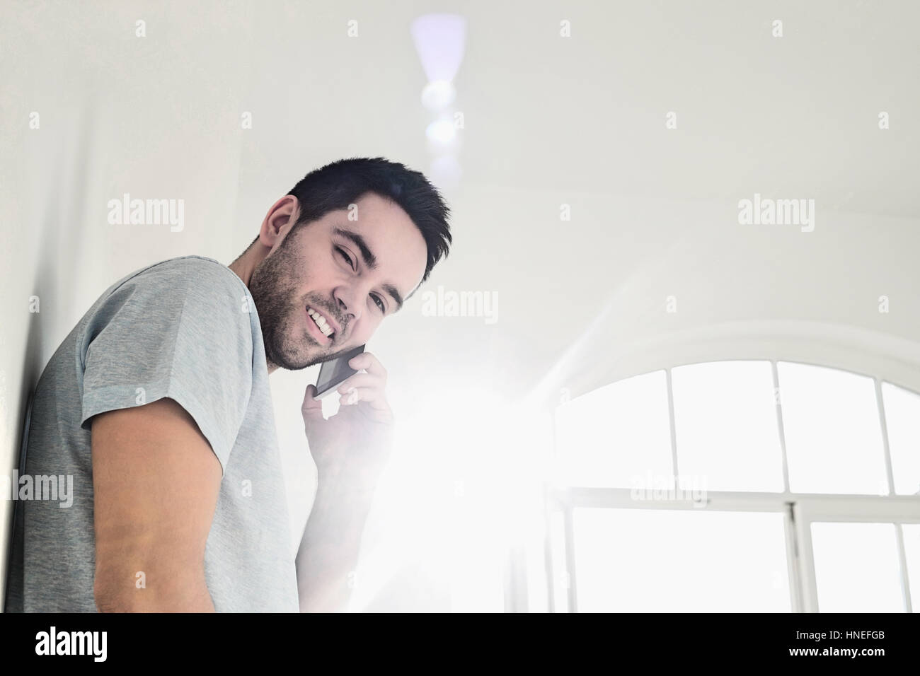 Portrait of handsome man on call at home Stock Photo - Alamy