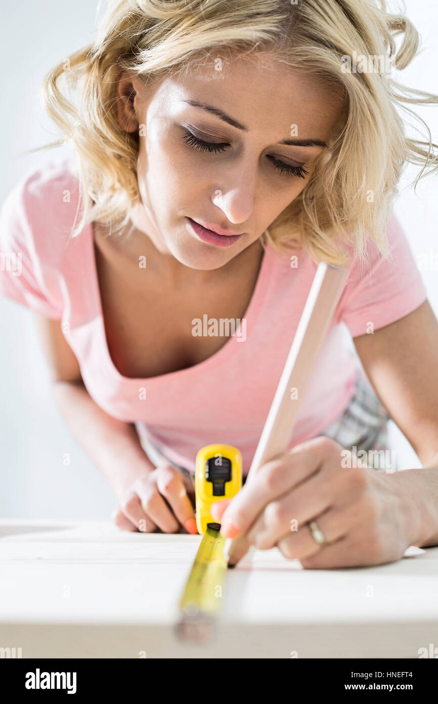 Beautiful woman marking table with measure tape Stock Photo - Alamy