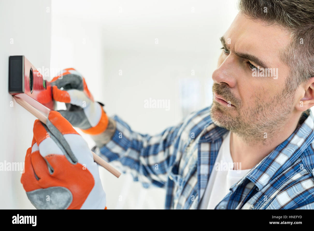 Mid-adult man marking on wall with level Stock Photo - Alamy