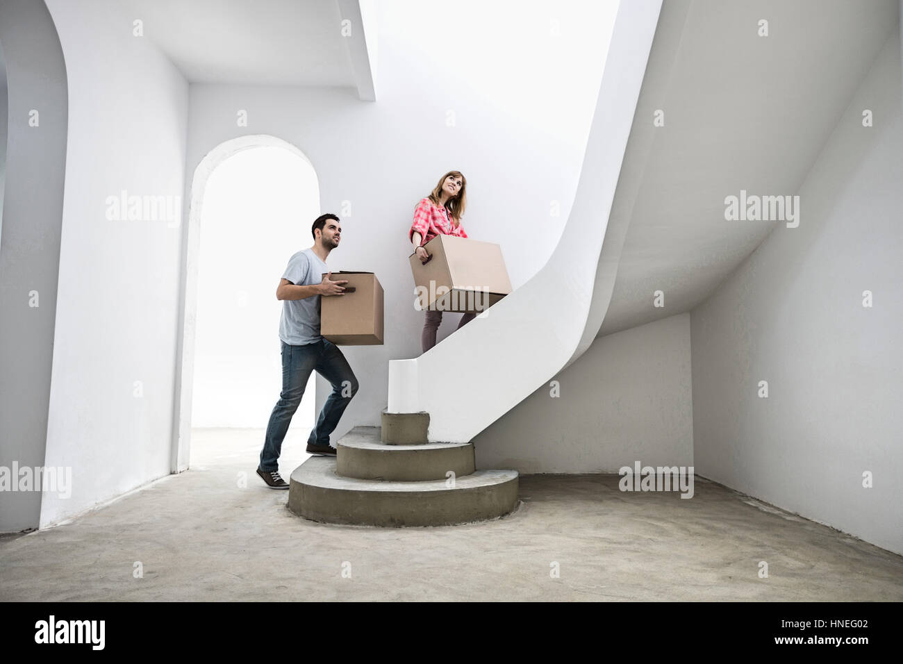 Couple Carrying Cardboard Boxes Up Stairs In New House Stock Photo Alamy