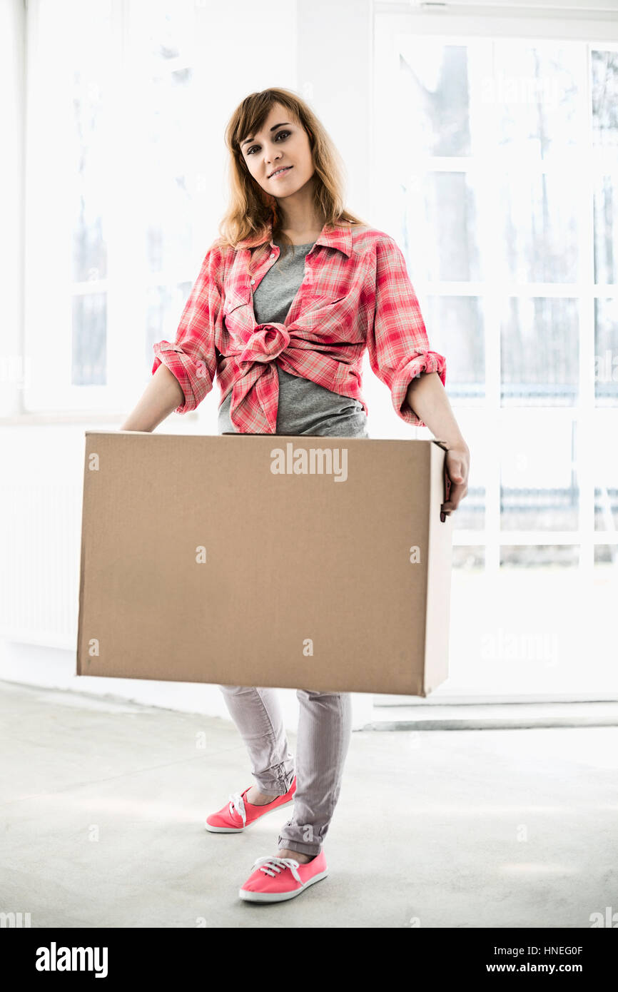 Full-length portrait of woman carrying cardboard box Stock Photo - Alamy