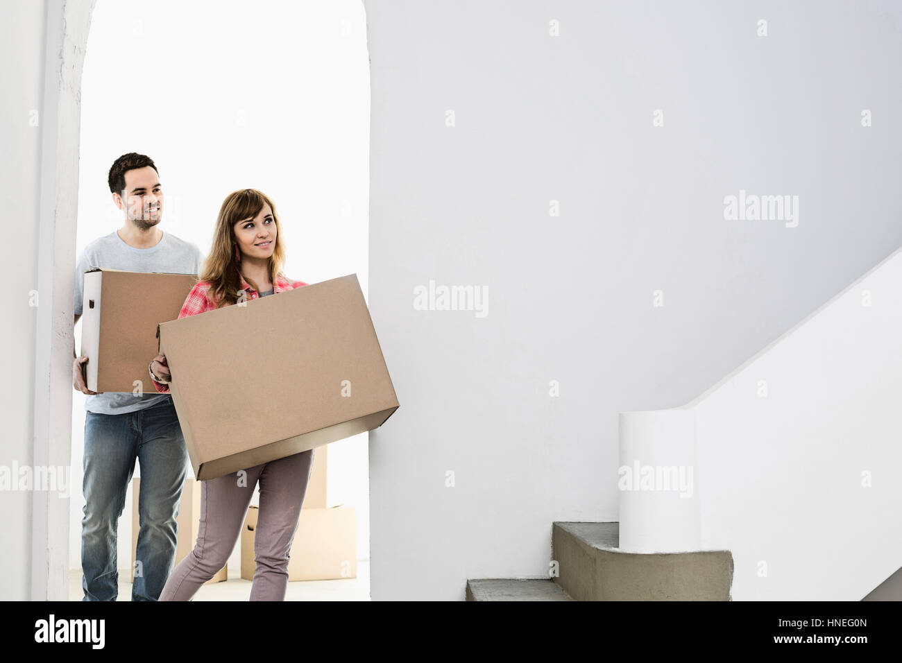 Couple carrying moving boxes Stock Photo - Alamy