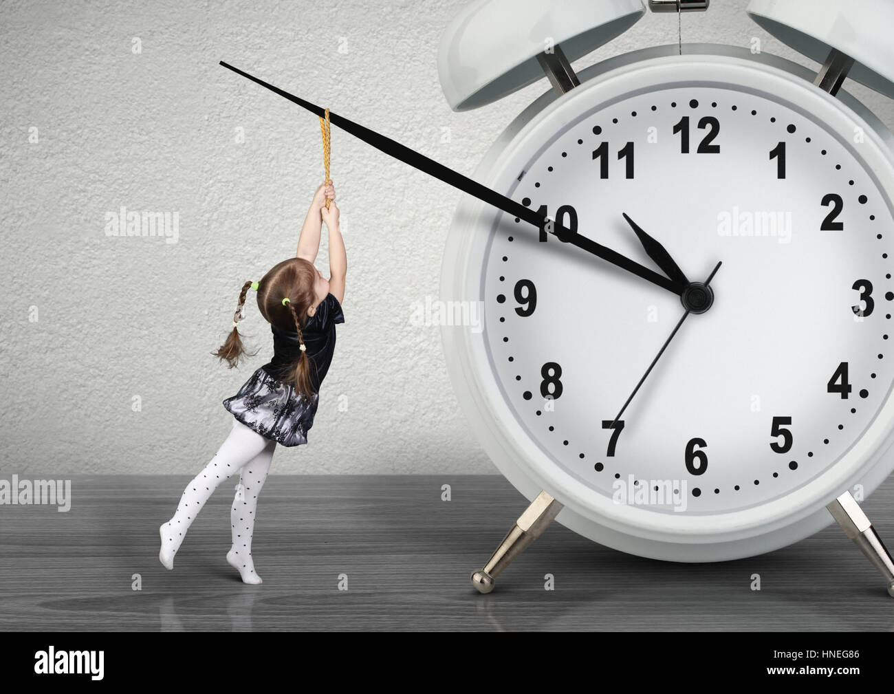 Little child girl pulling hand clock, time management concept Stock ...