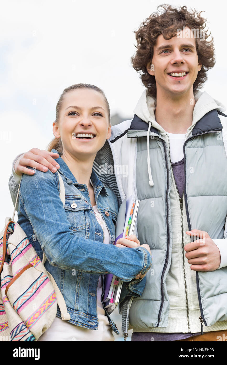 Happy young college students standing arm around at campus Stock Photo ...