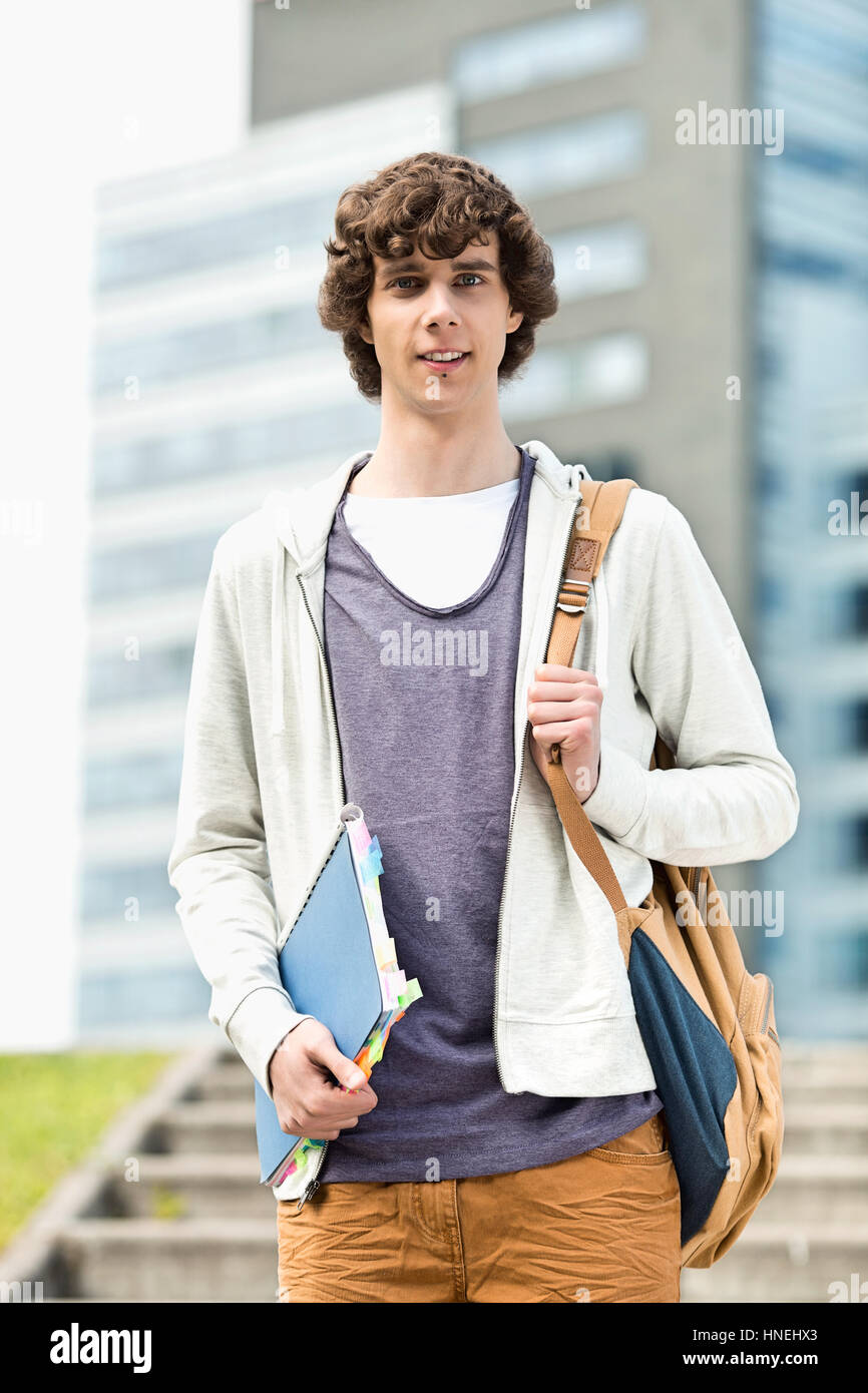 Portrait of young man standing at college campus Stock Photo - Alamy