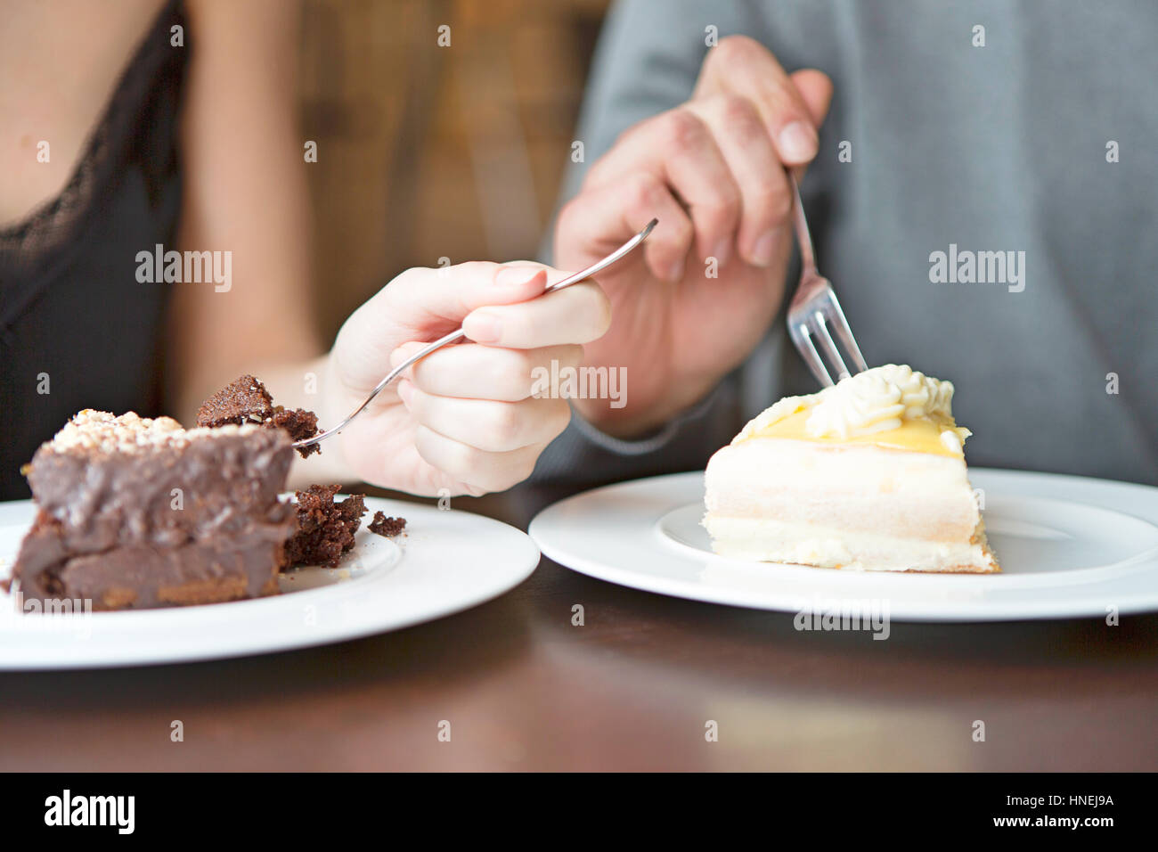 Cropped image of couple having pastries Stock Photo - Alamy