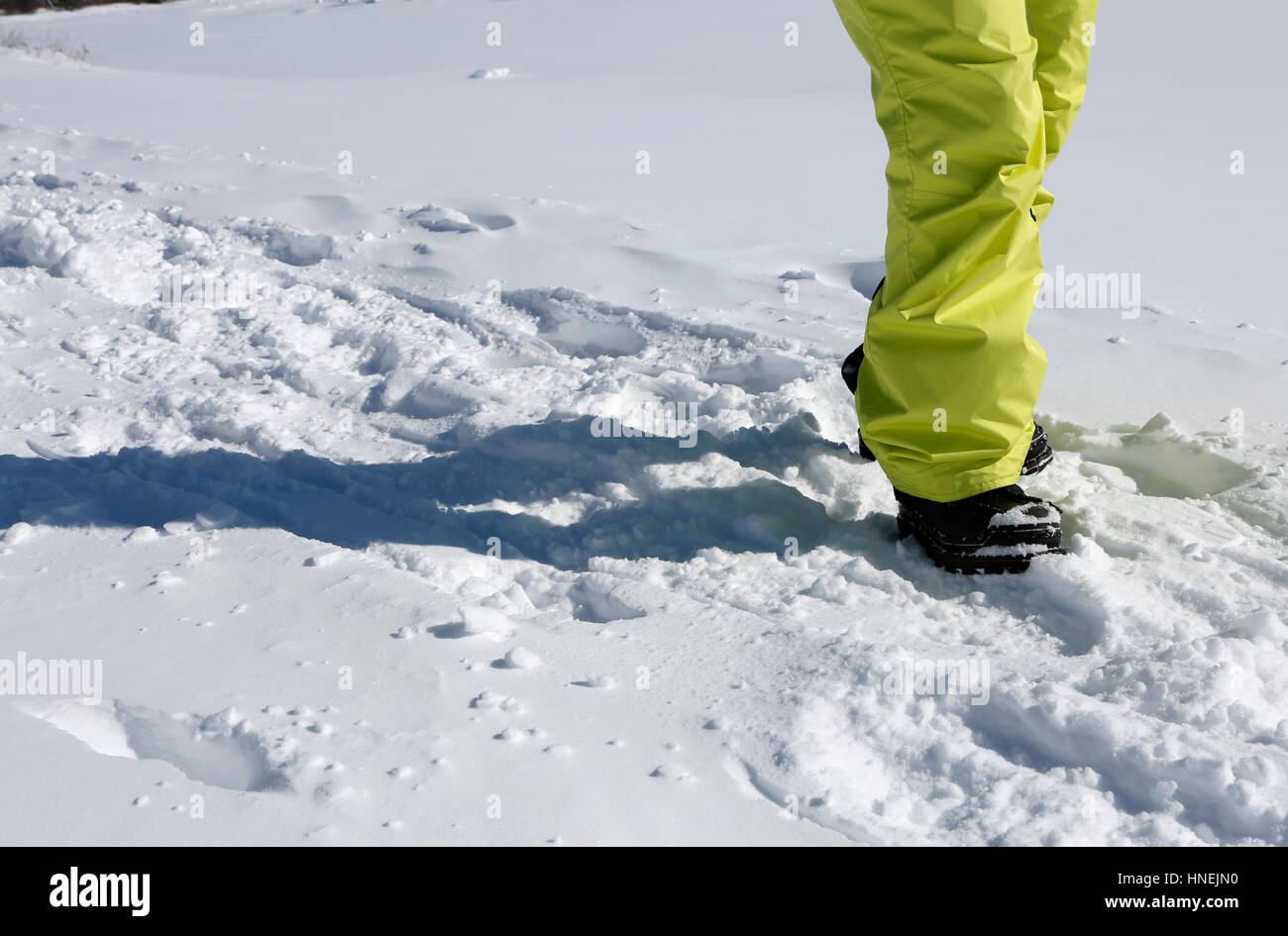 Woman walking a snow path on bright sunny day Stock Photo - Alamy