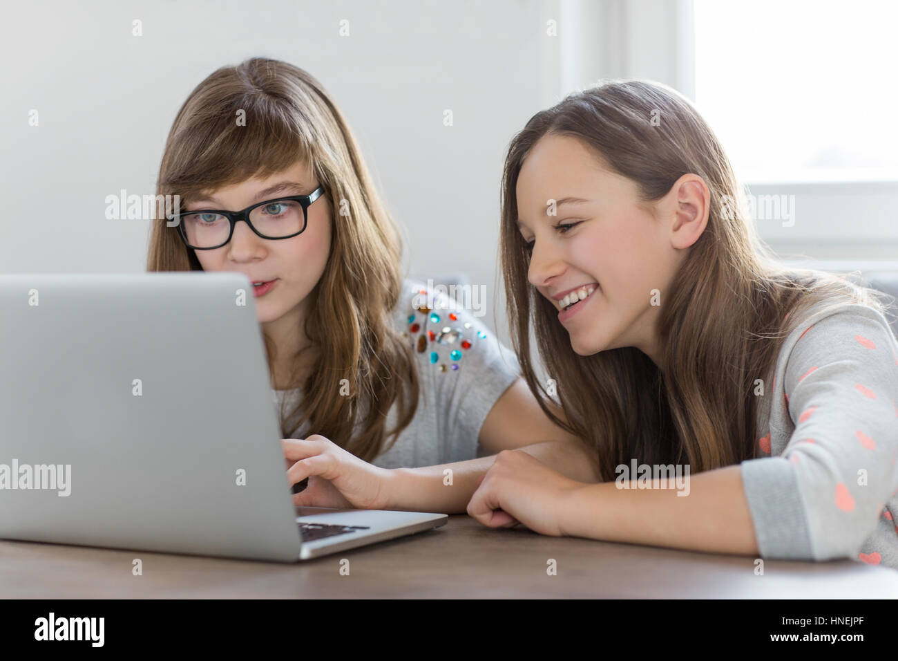 Sisters using laptop together at home Stock Photo - Alamy