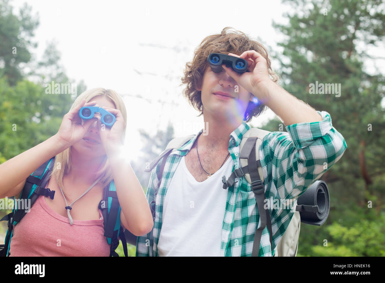 Young hiking couple using binoculars in forest Stock Photo - Alamy
