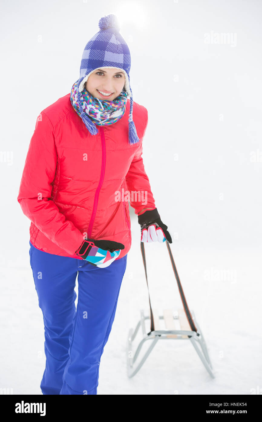 Beautiful young woman pulling sled Stock Photo - Alamy