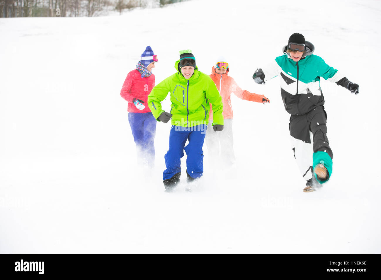 Full length of young friends having fun in snow Stock Photo - Alamy