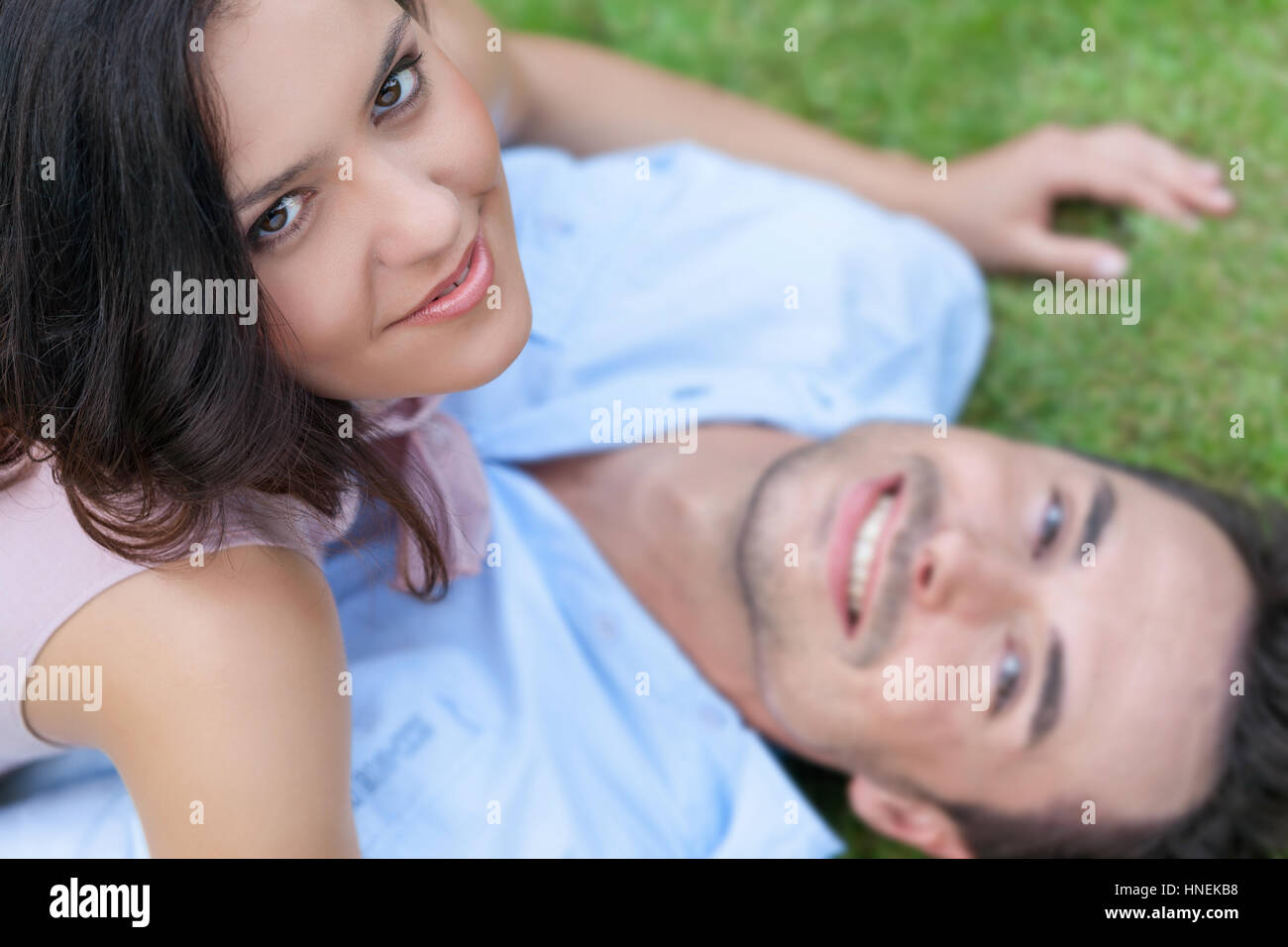 High angle portrait of playful young woman on top of man in park Stock ...