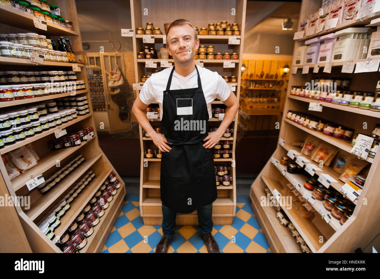 Full length portrait of mid adult salesman standing hands on hips in ...
