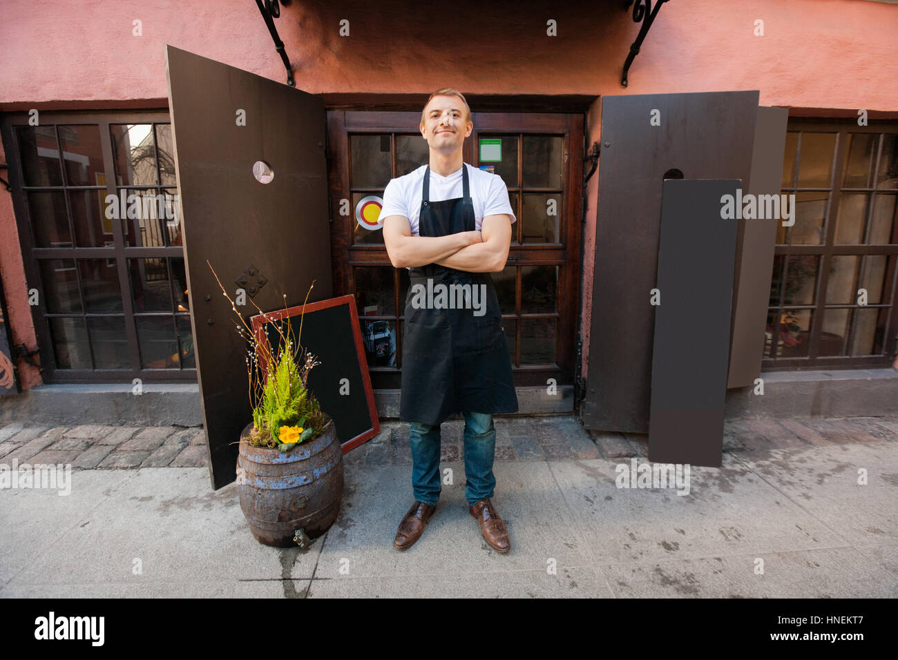 Portrait of confident male salesperson standing arms crossed outside ...