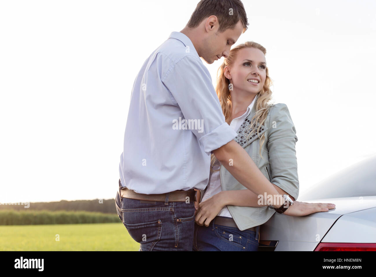Romantic young couple leaning on back of car at countryside Stock Photo ...