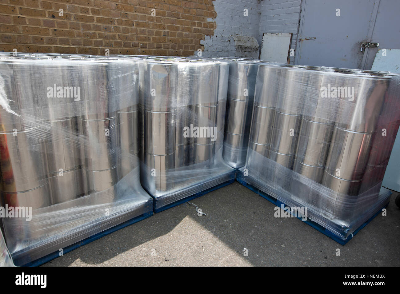 Stack of tins outside warehouse Stock Photo - Alamy