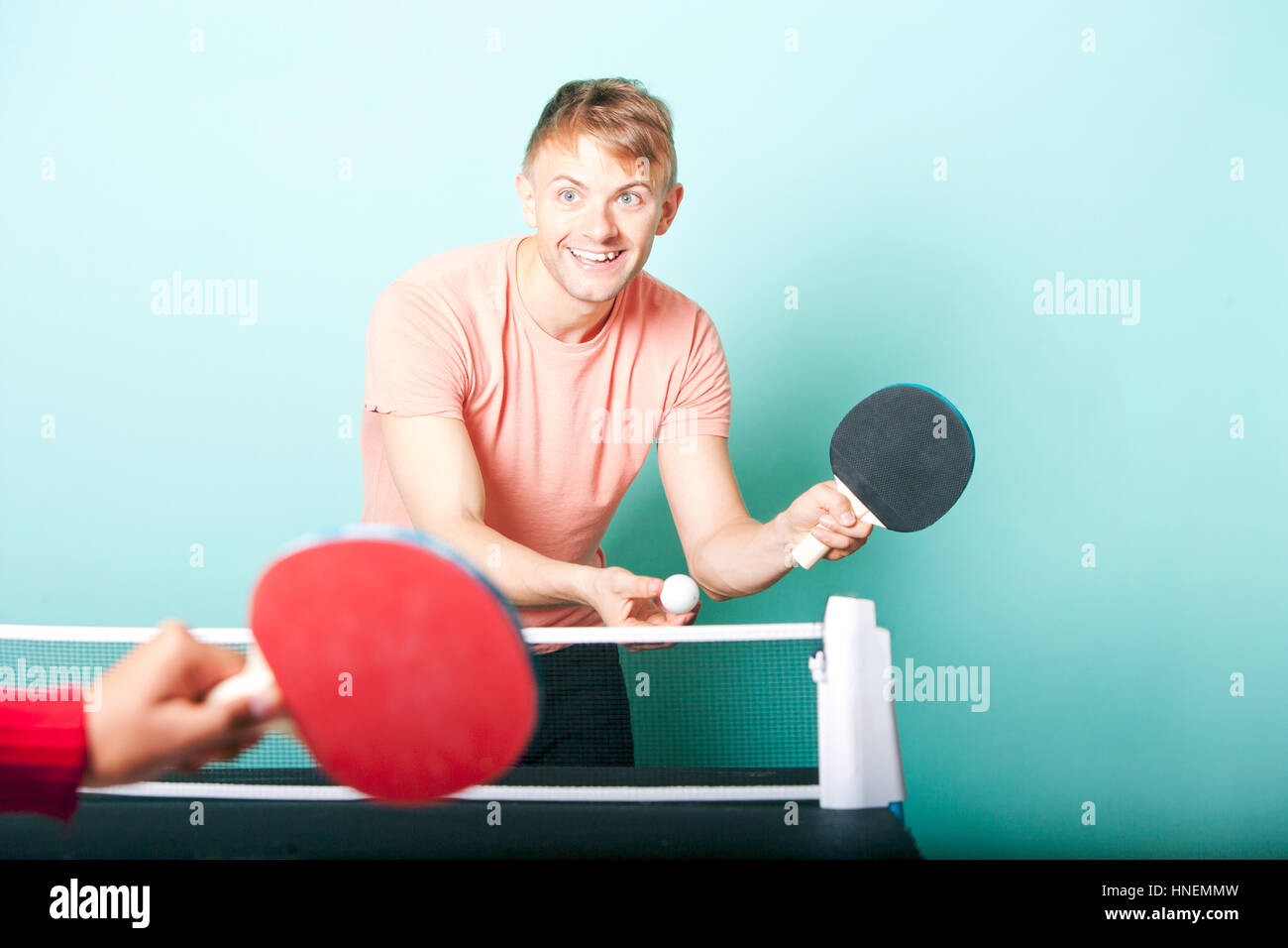 Caucasian man playing table tennis with friend Stock Photo - Alamy
