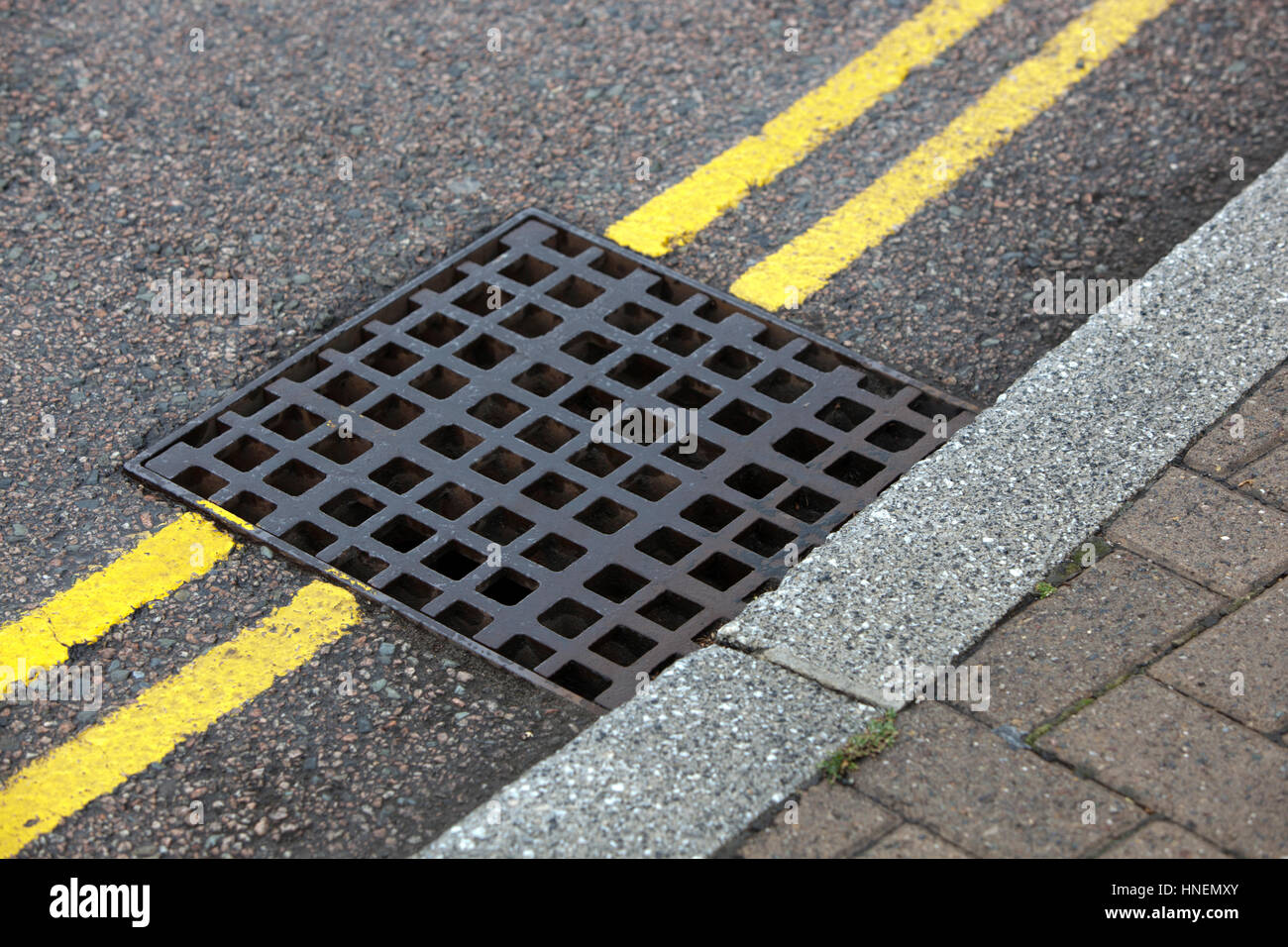 Street drain over Double yellow line on street Stock Photo - Alamy