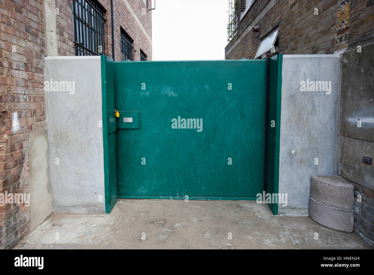Closed green gate connected to buildings Stock Photo - Alamy