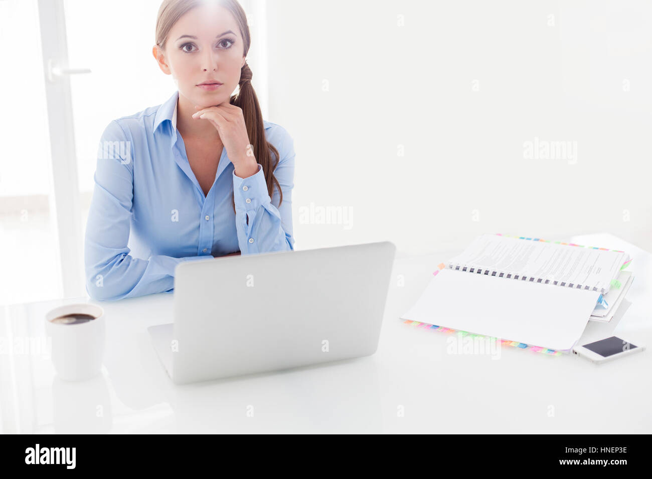 Businesswoman looking bored in front of laptop Stock Photo - Alamy