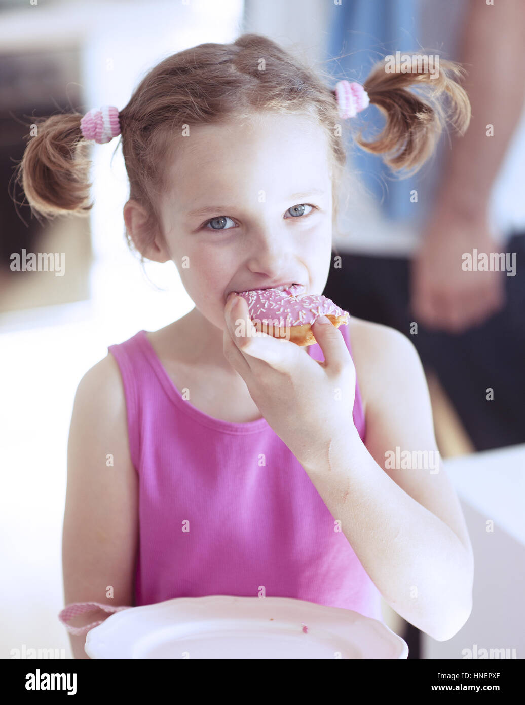 Young girl eating cake in kitchen Stock Photo - Alamy