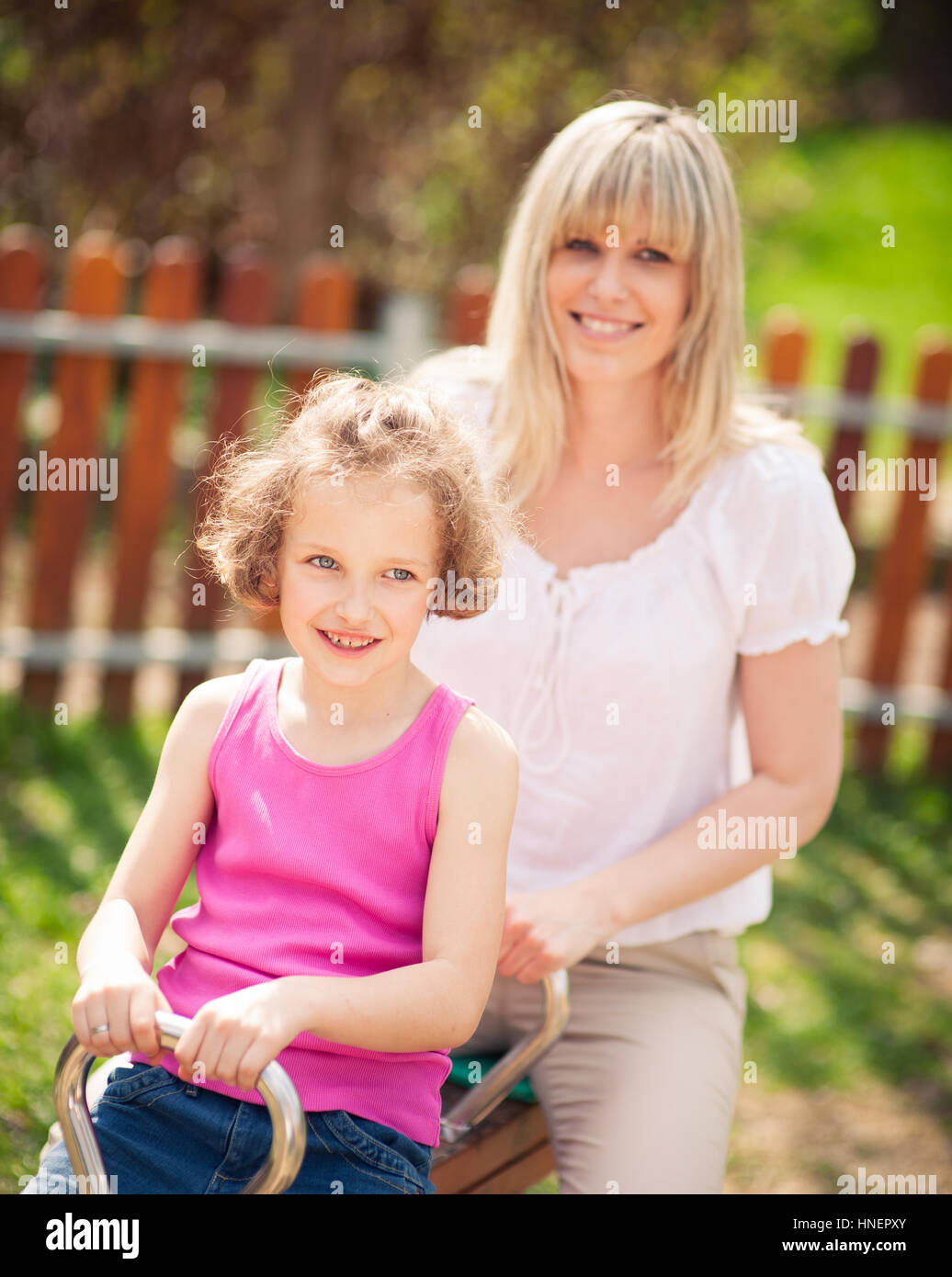 Mother and daughter ride seesaw together Stock Photo - Alamy
