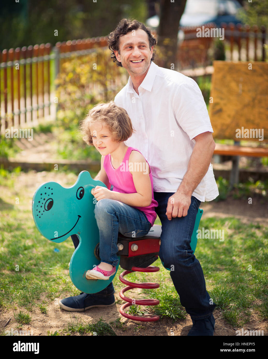 Father and daughter on playground spring rider Stock Photo - Alamy