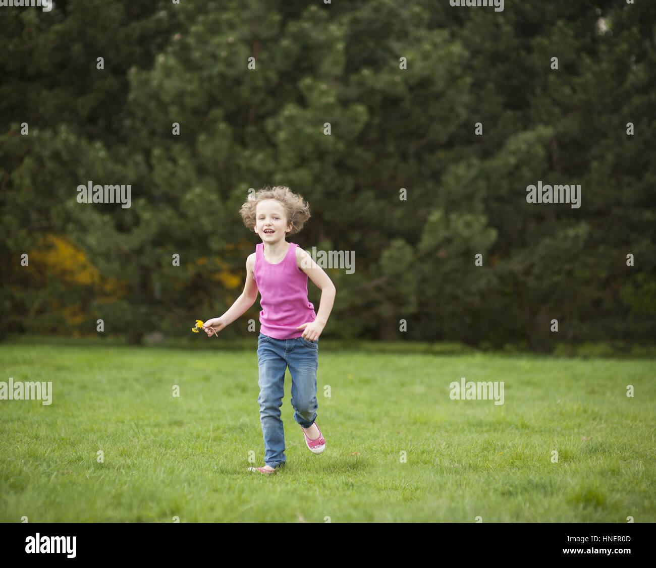 Young girl running through park in summer Stock Photo - Alamy