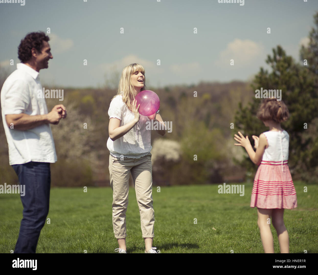 Family throwing ball to each other in the park Stock Photo - Alamy