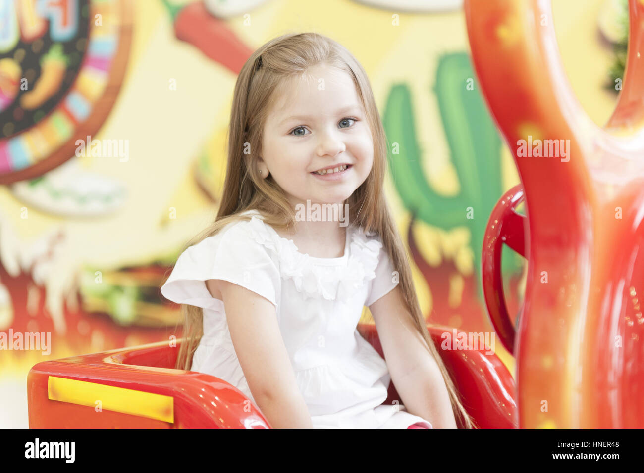 Young girl sitting on childrens car ride Stock Photo - Alamy