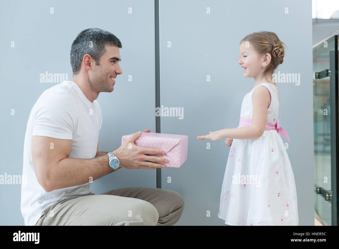 Young girl handing present to her father Stock Photo - Alamy