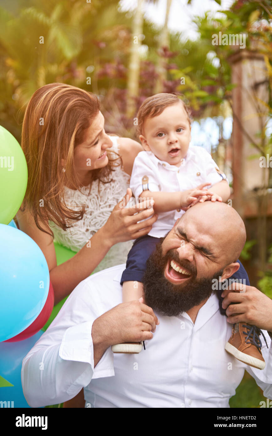 laughing beard father with family holding his son on shoulders in ...