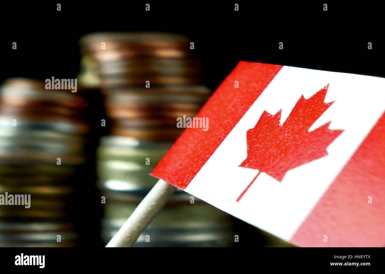 Canada flag waving with stack of money coins macro Stock Photo - Alamy