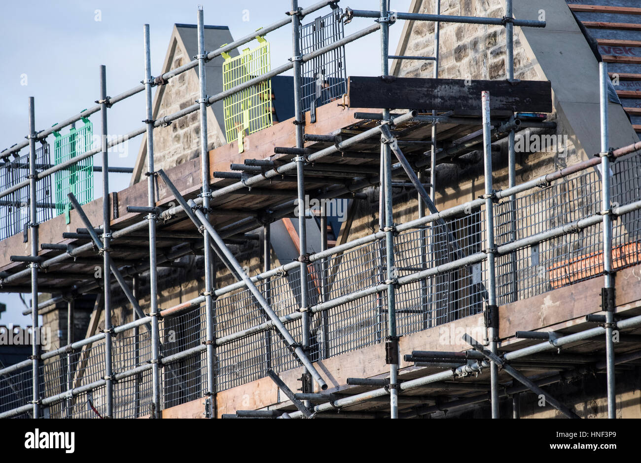 Safety scaffolding on a new building with a traditional stone face ...